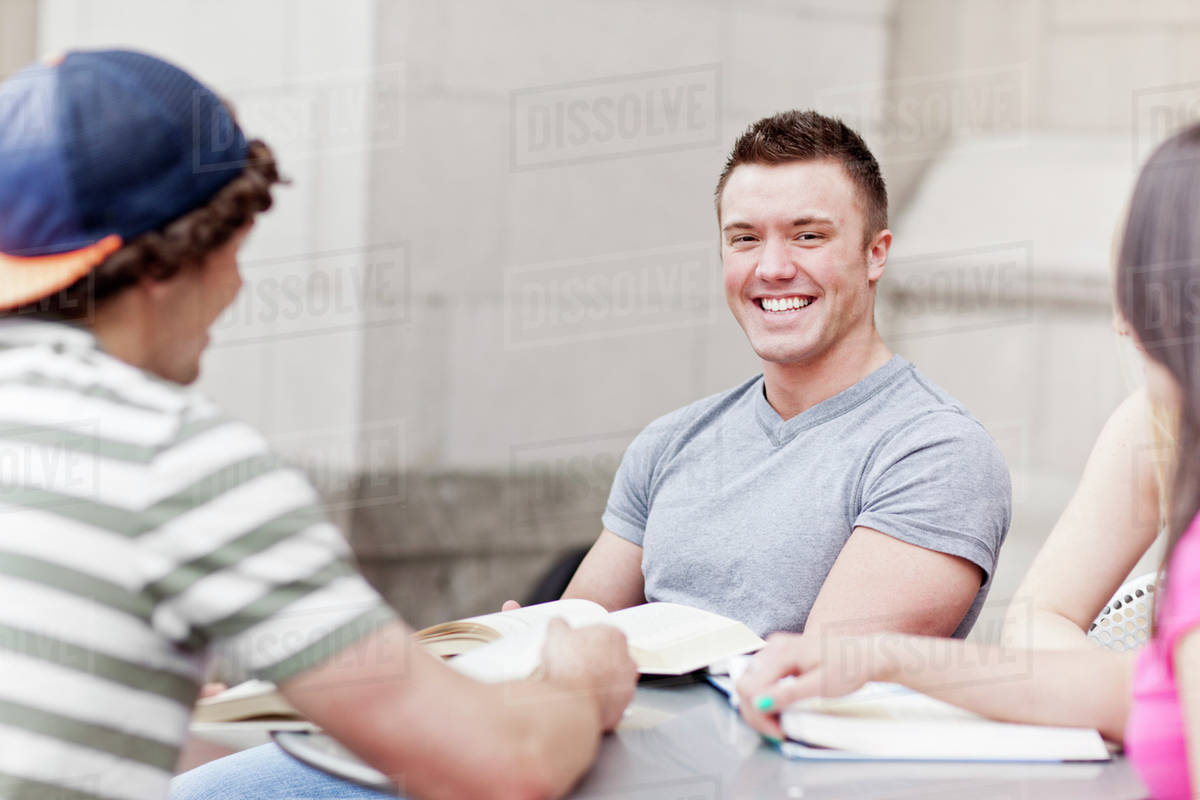 Three college students sitting at cafe table - Royalty-free Stock Photo ...
