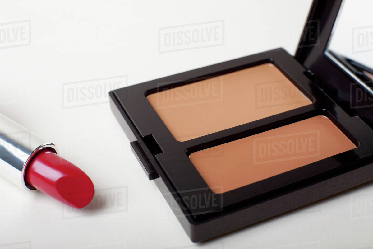 Powder compact with red lipstick - Stock Photo - Dissolve