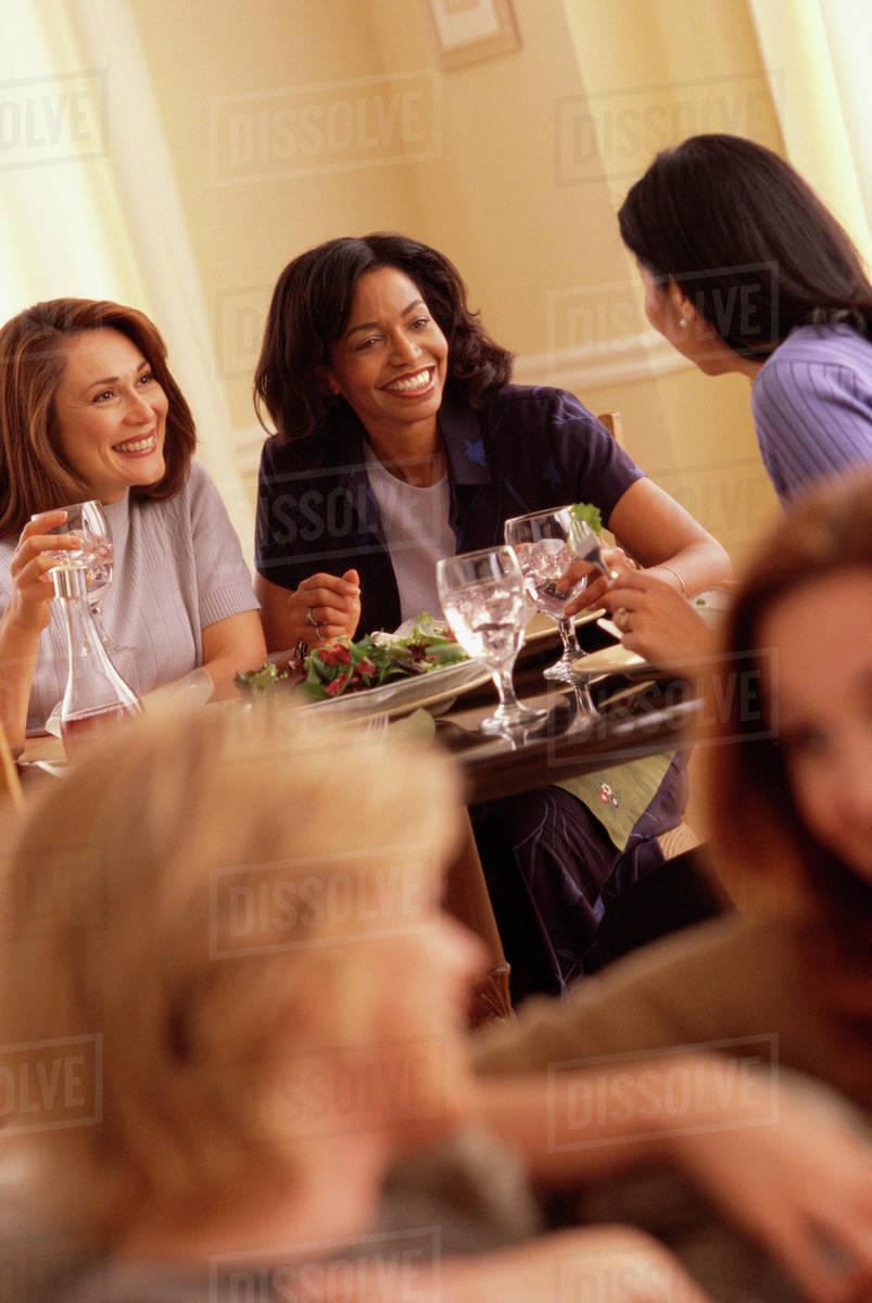 Woman laughing over dinner - Royalty-free Stock Photo | Dissolve