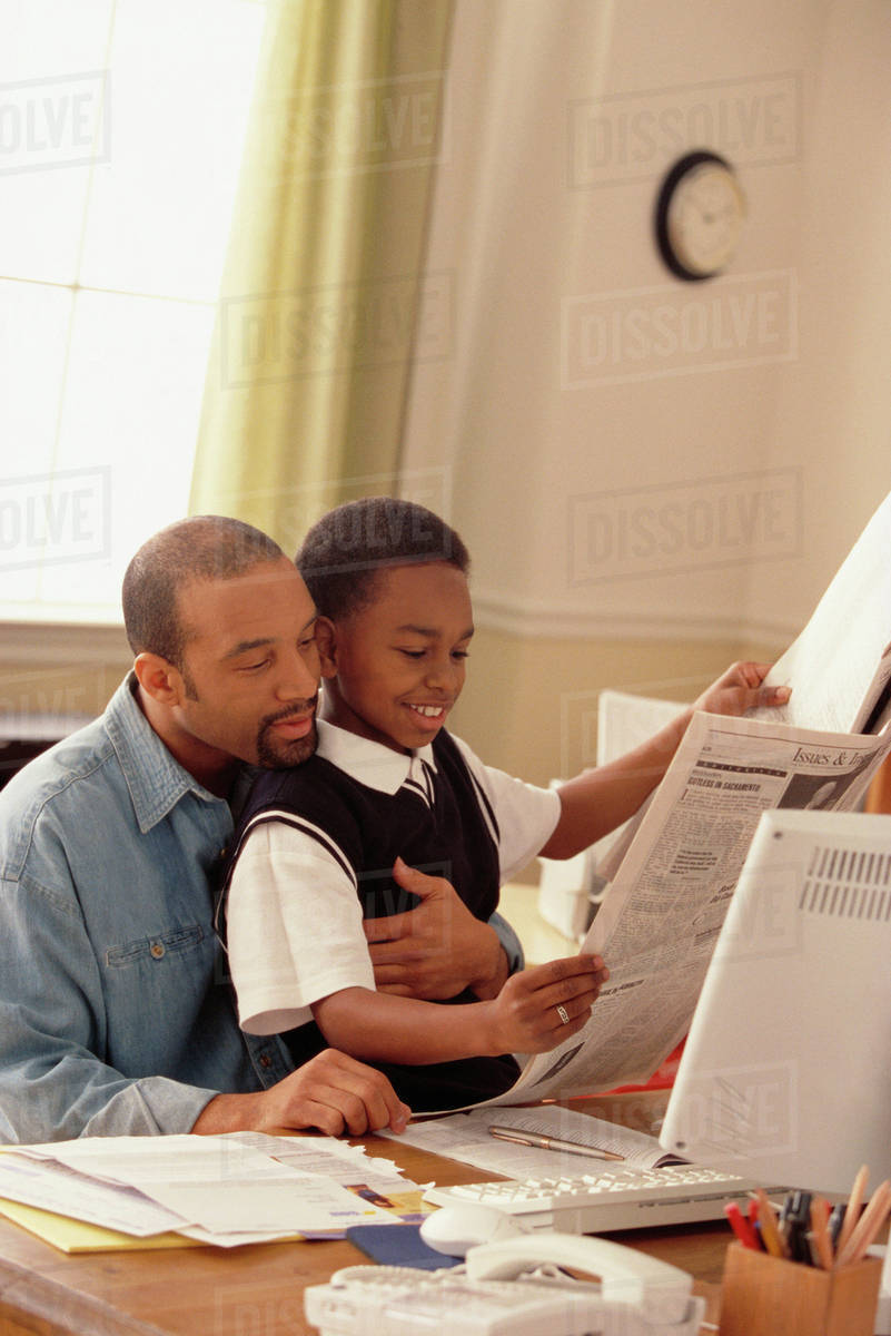 Father and son reading newspaper - Royalty-free Stock Photo | Dissolve