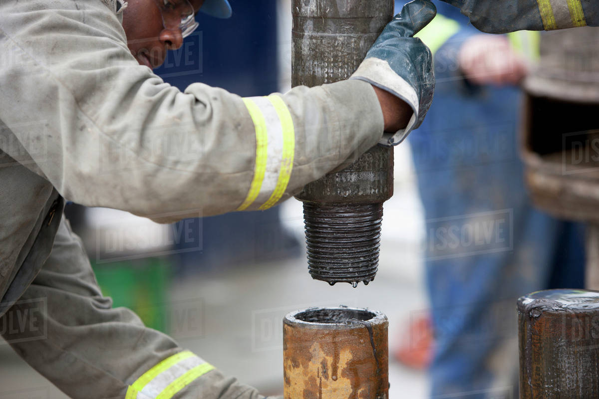 Oil worker drilling for oil on rig - Stock Photo - Dissolve