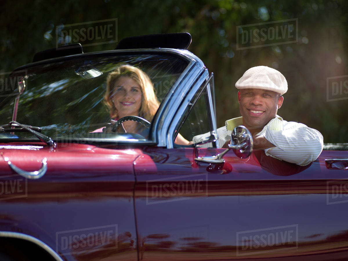 Smiling couple driving classic's car - Royalty-free Stock Photo | Dissolve
