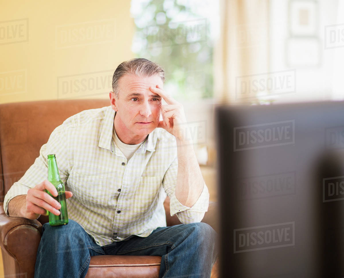 Portrait of man watching tv - Stock Photo - Dissolve