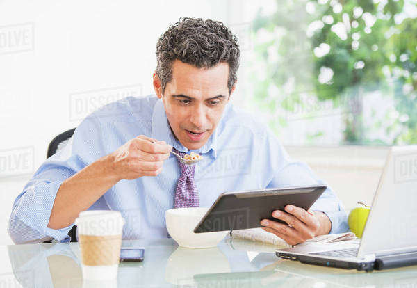 Portrait of man eating and using digital tablet - Royalty-free Stock ...