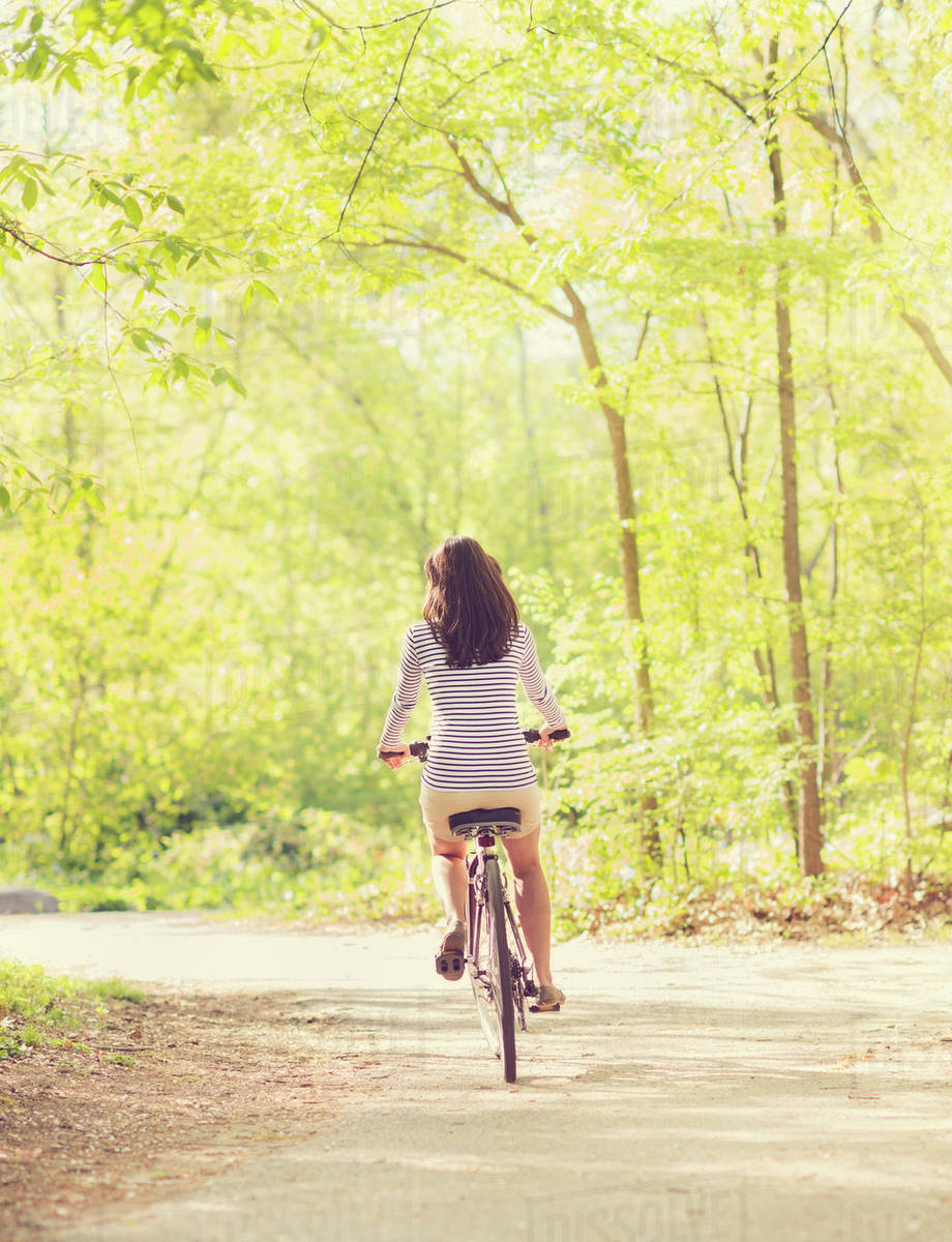 Mid adult woman riding bicycle - Royalty-free Stock Photo | Dissolve