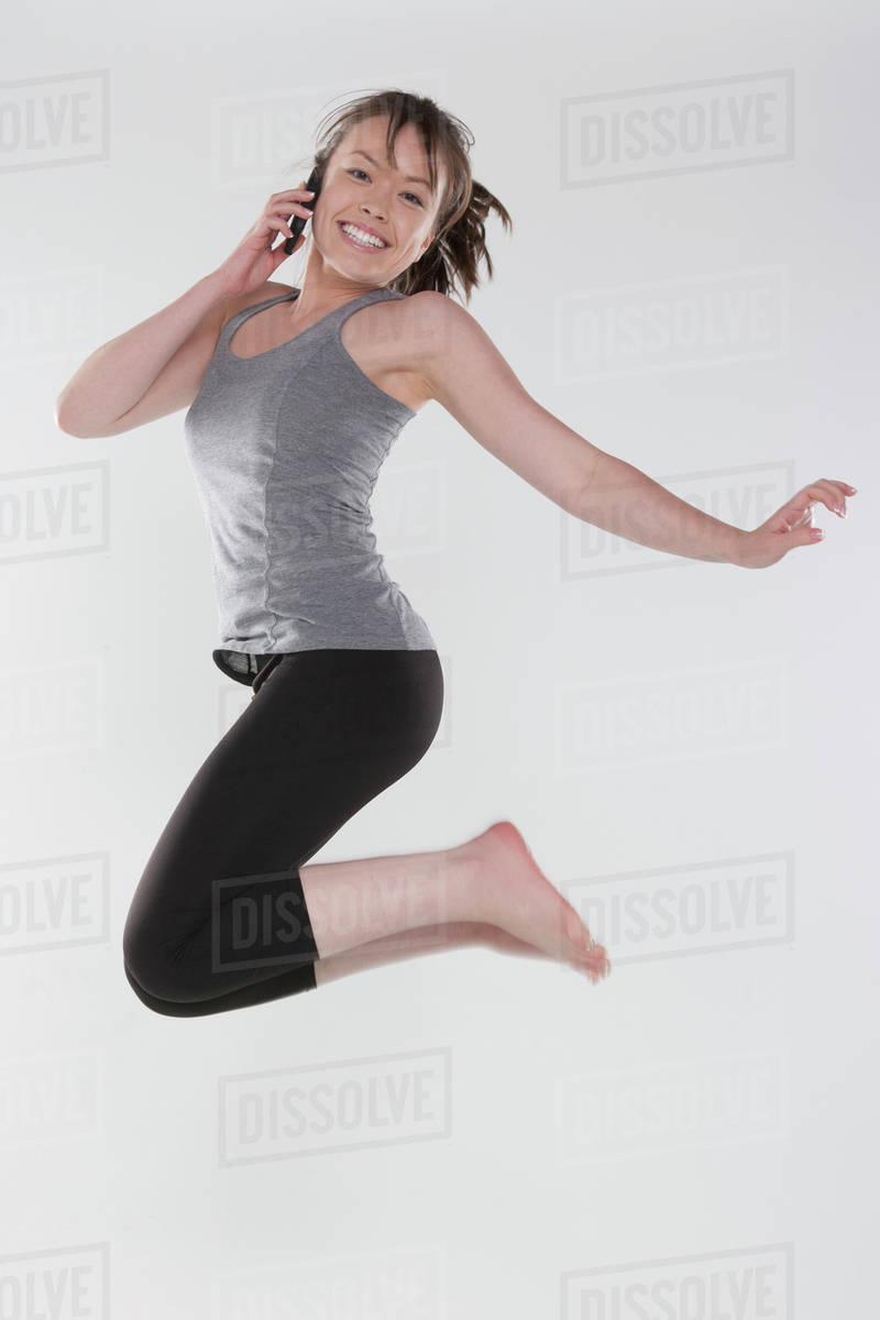 Portrait of young woman jumping, studio shot - Royalty-free Stock Photo ...