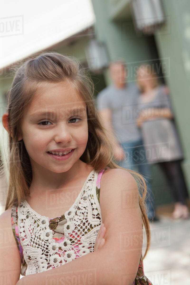 Portrait of cheerful girl (6-7) with parents in background - Stock ...