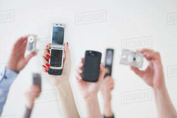 Hands holding wireless devices - Stock Photo - Dissolve