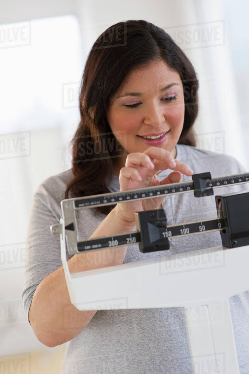 Woman standing on scale - Stock Photo - Dissolve