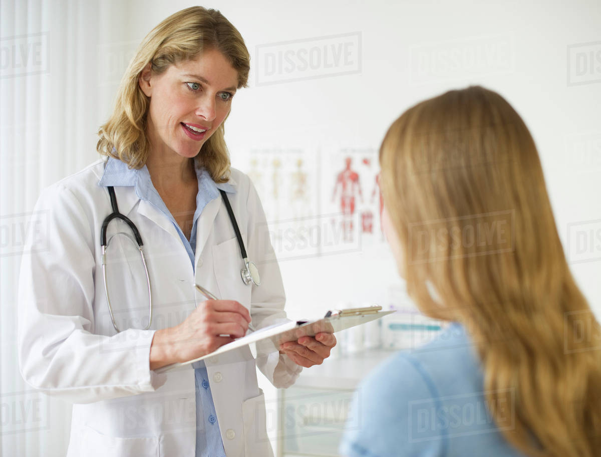Doctor talking to patient in exam room - Stock Photo - Dissolve
