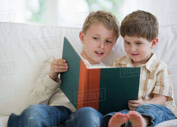 Brothers reading a book together - Royalty-free Stock Photo | Dissolve