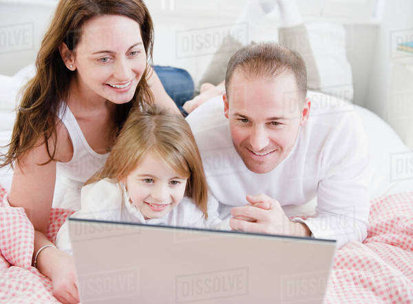 Family looking at laptop - Royalty-free Stock Photo | Dissolve