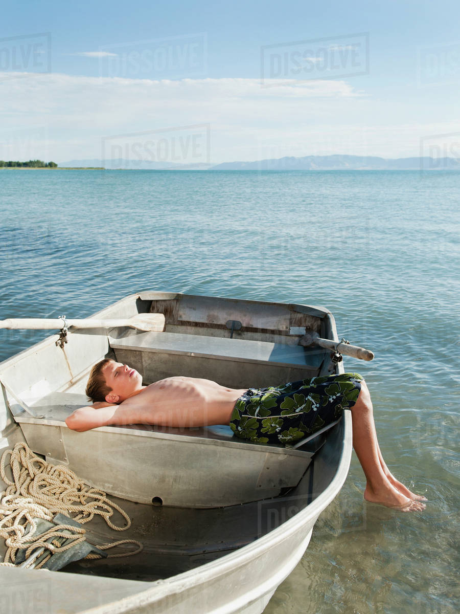Boy (10-11) resting on boat - Royalty-free Stock Photo | Dissolve