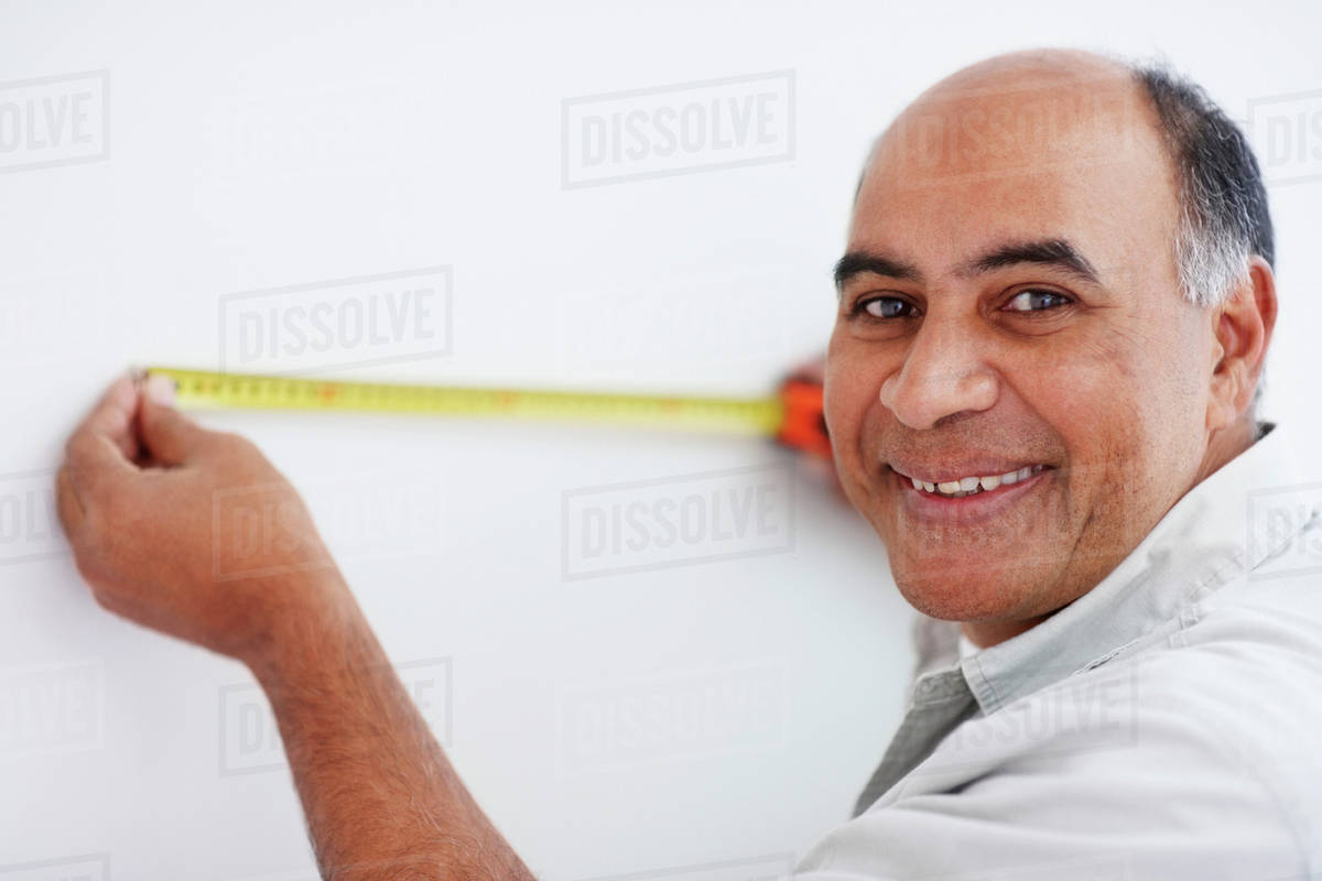 Man measuring wall - Royalty-free Stock Photo | Dissolve