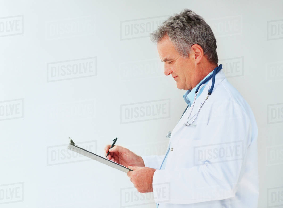 Doctor writing on clipboard - Royalty-free Stock Photo | Dissolve