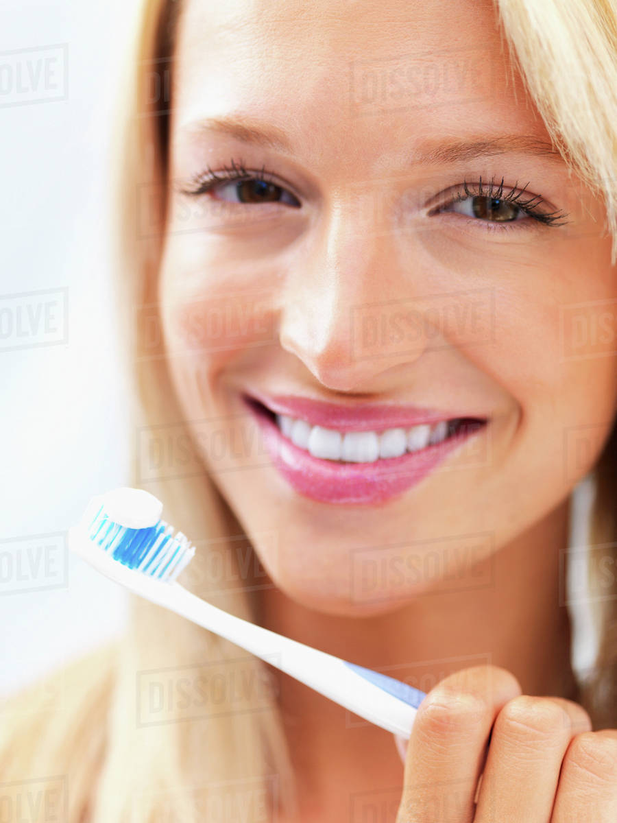Woman holding a toothbrush - Stock Photo - Dissolve