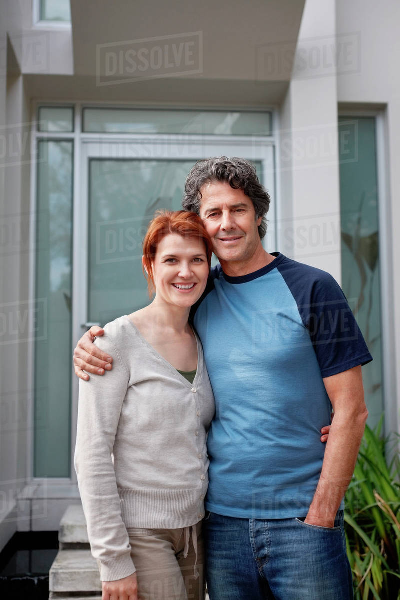 Happy couple standing with their arms around one another - Royalty-free ...