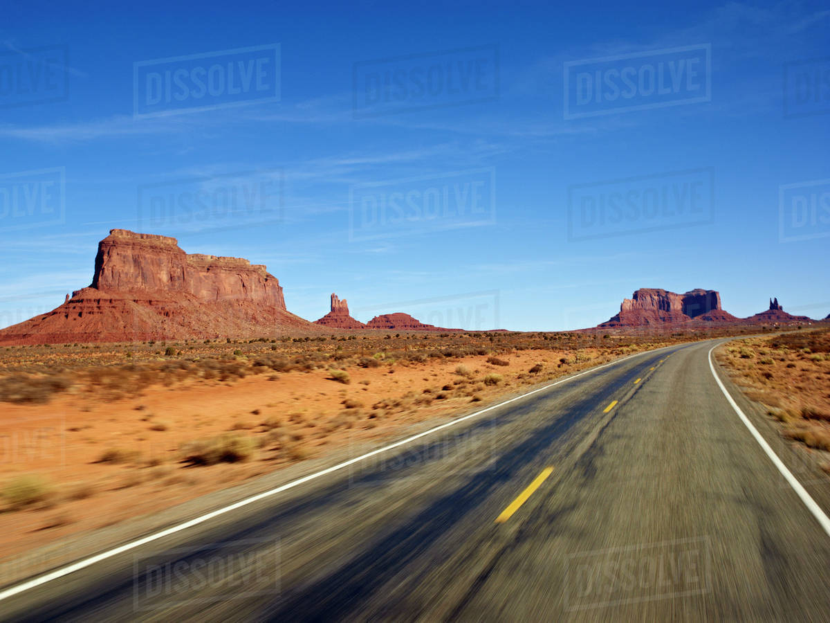 Desolate road through the desert - Stock Photo - Dissolve