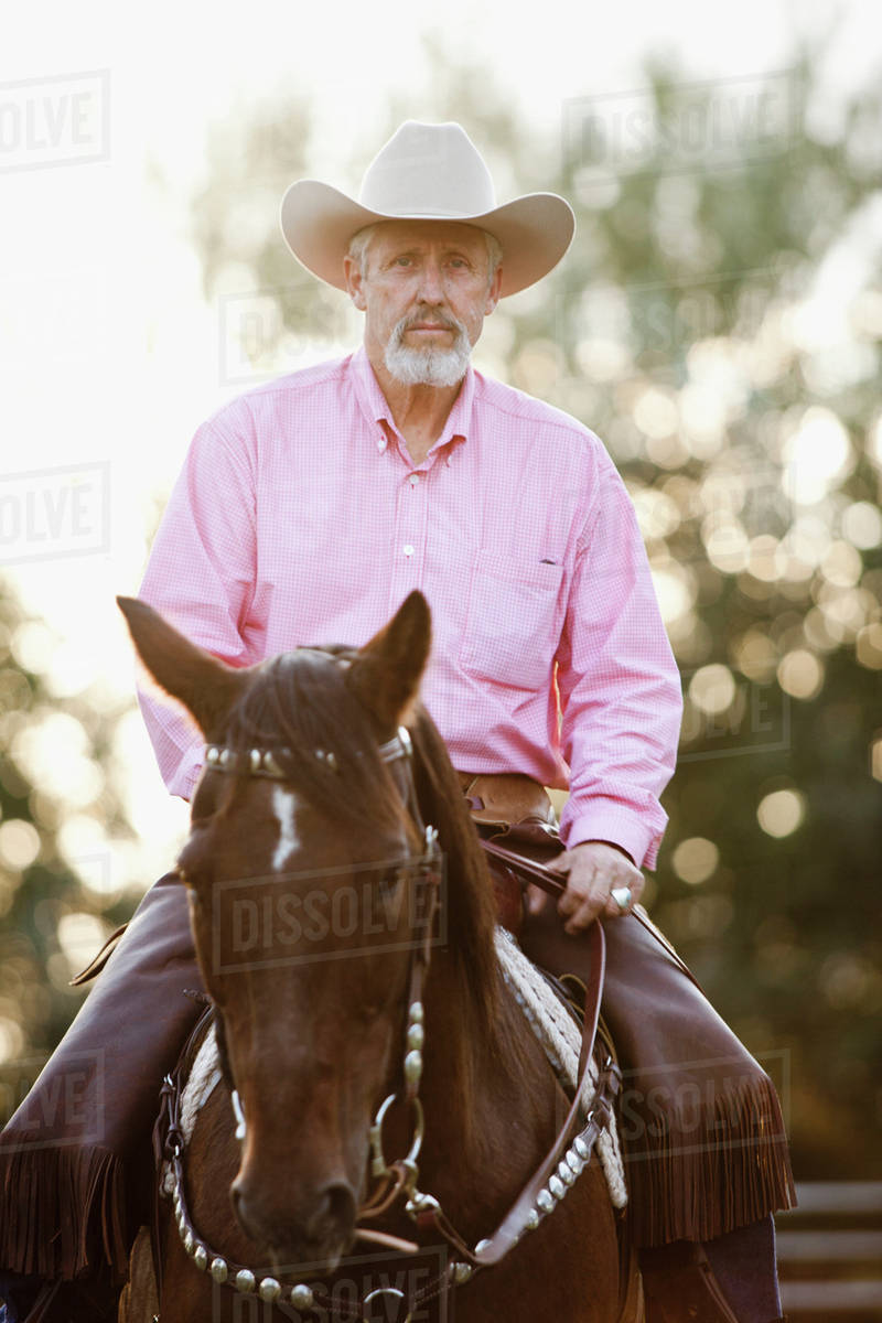 Portrait of senior man horseback riding in ranch - Royalty-free Stock ...