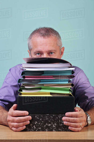 Man sitting behind a stack of paper work - Royalty-free Stock Photo ...
