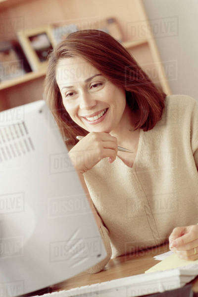 Woman working at computer - Stock Photo - Dissolve