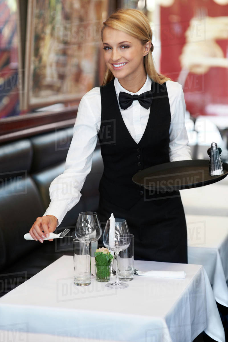 Portrait of young waitress setting table - Royalty-free Stock Photo ...