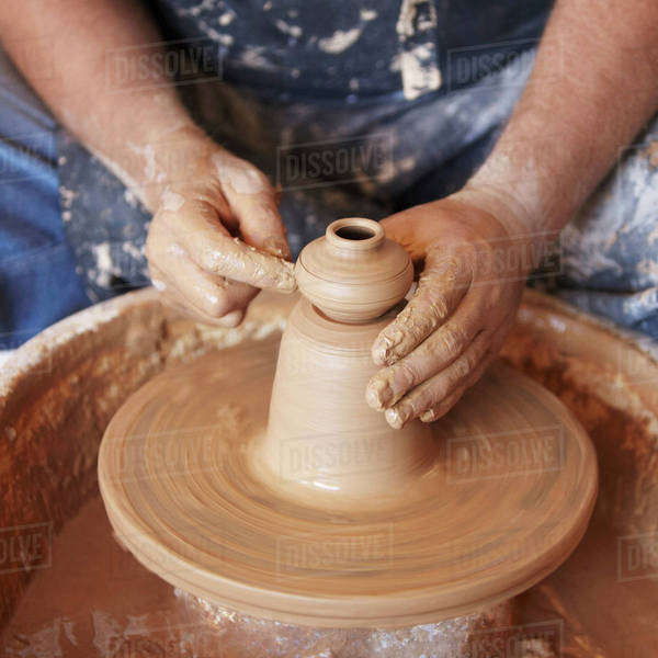 Elevated view of hands working with clay on potter's wheel - Royalty ...