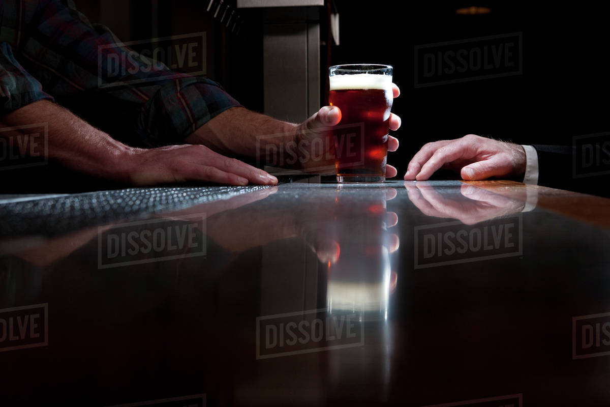 Bartender serving a beer - Royalty-free Stock Photo | Dissolve