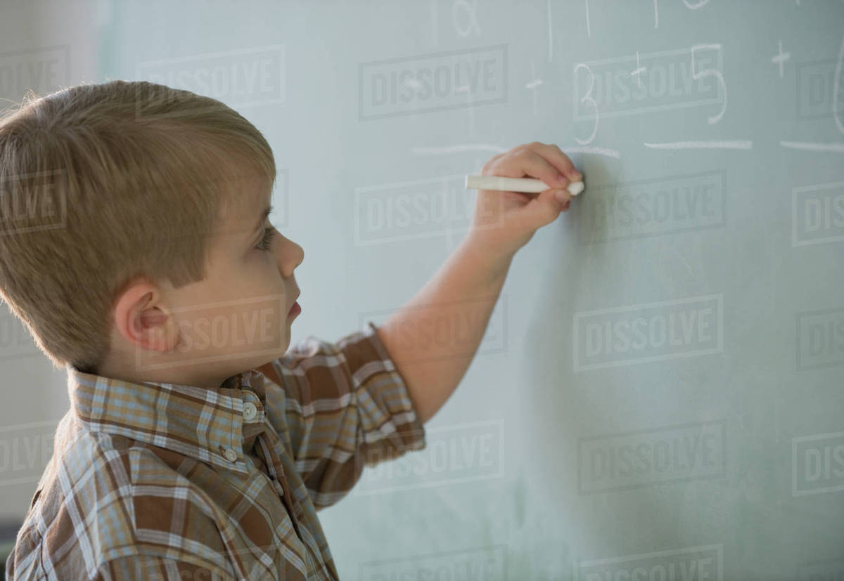 Boy doing math on blackboard - Royalty-free Stock Photo | Dissolve