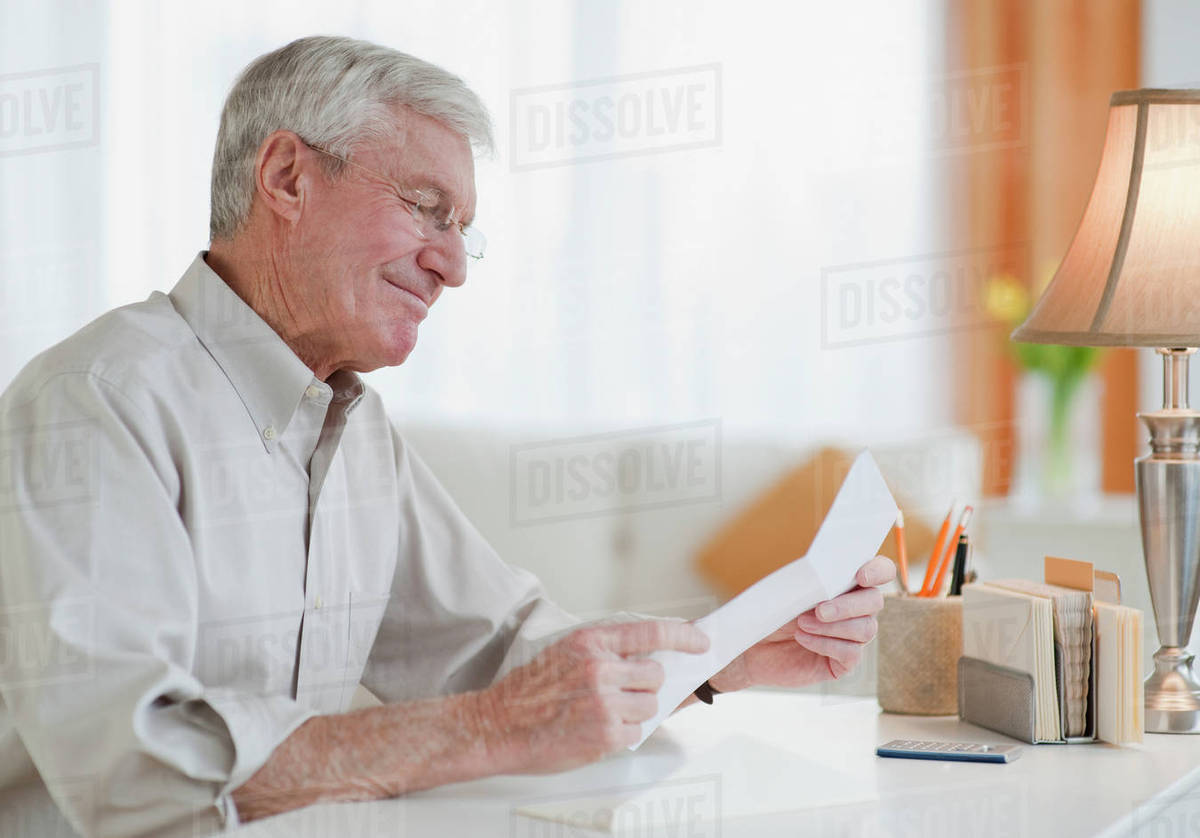 Senior man reading letter - Stock Photo - Dissolve
