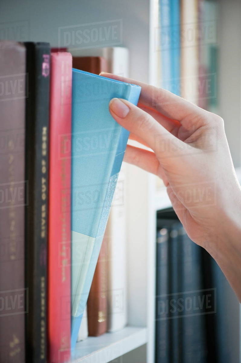 Woman removing book from shelf, close-up - Royalty-free Stock Photo ...