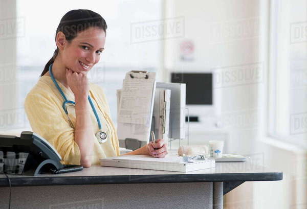 Female nurse at desk - Stock Photo - Dissolve