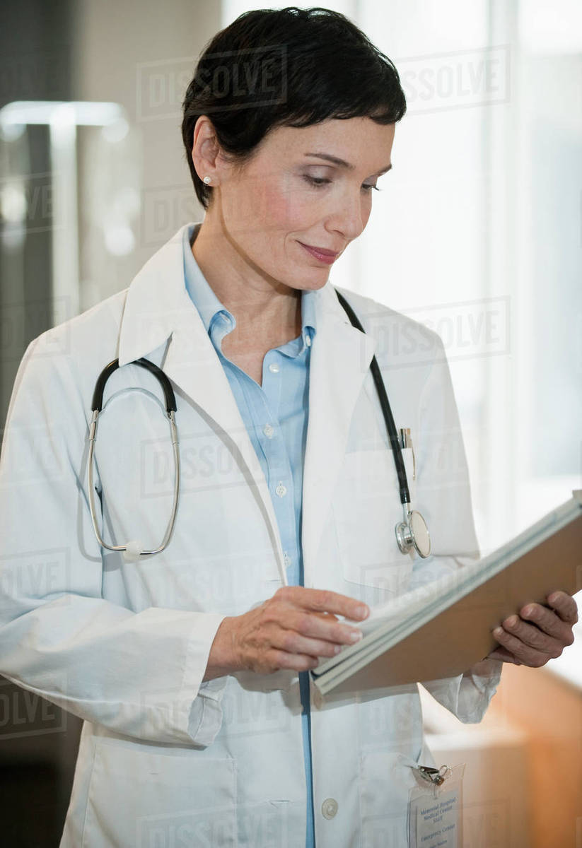 Doctor looking at chart - Stock Photo - Dissolve