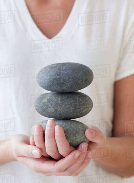 Woman holding stack of spa stones - Royalty-free Stock Photo | Dissolve
