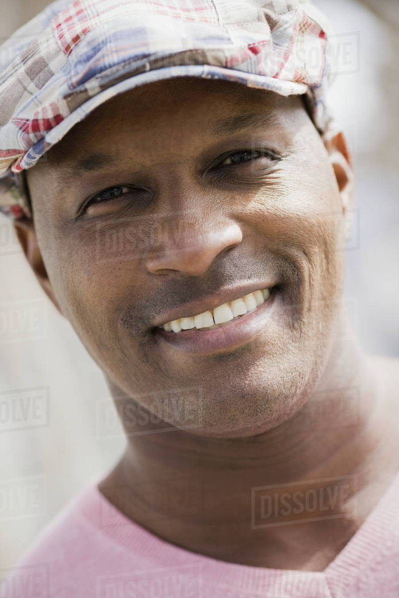 Portrait of man wearing cap, smiling - Stock Photo - Dissolve