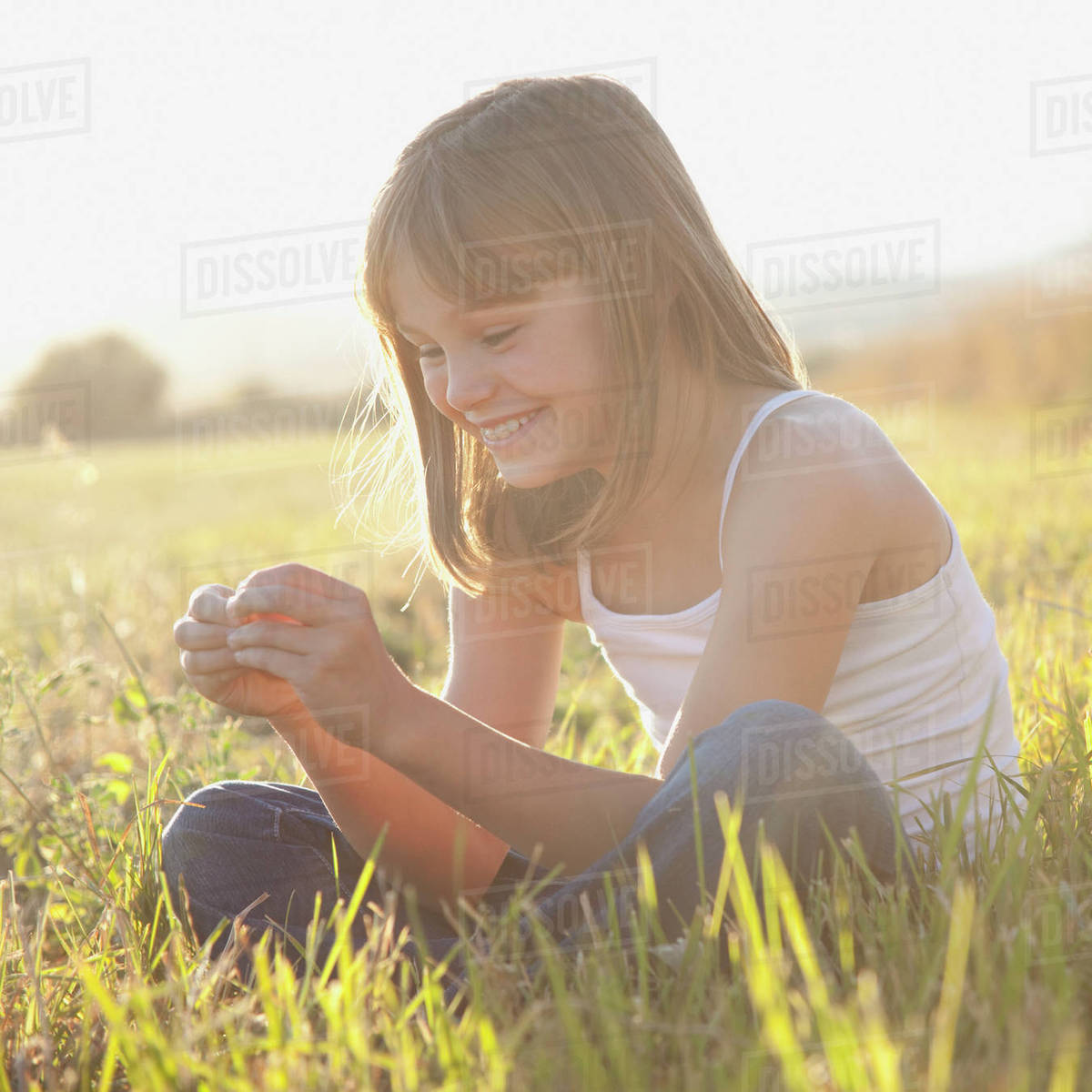 Portrait of young girl sitting in field - Royalty-free Stock Photo ...