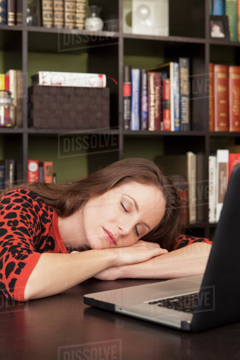 Woman sleeping next to laptop - Royalty-free Stock Photo | Dissolve