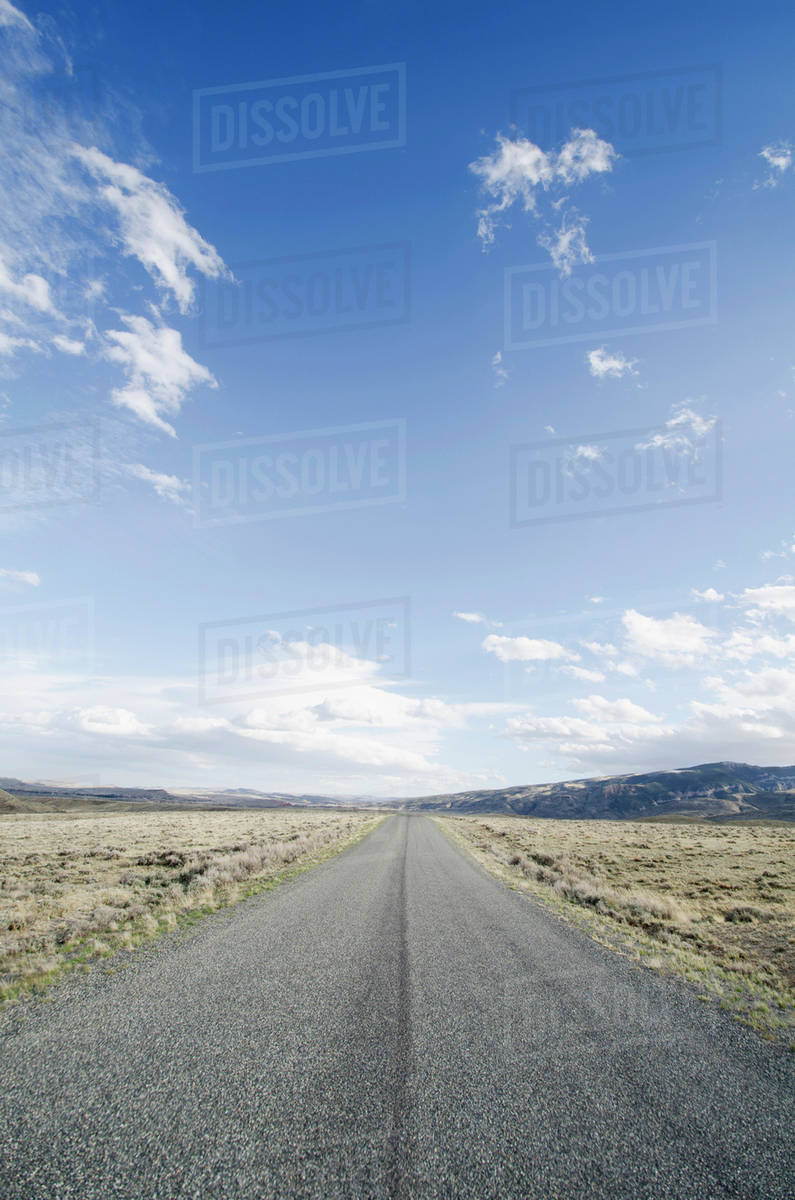 Road going through desolate landscape - Stock Photo - Dissolve
