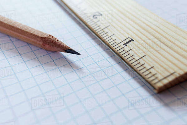 Ruler and pencil on graph paper, studio shot - Stock Photo - Dissolve