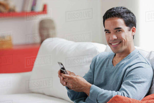 Man texting in living room - Royalty-free Stock Photo | Dissolve