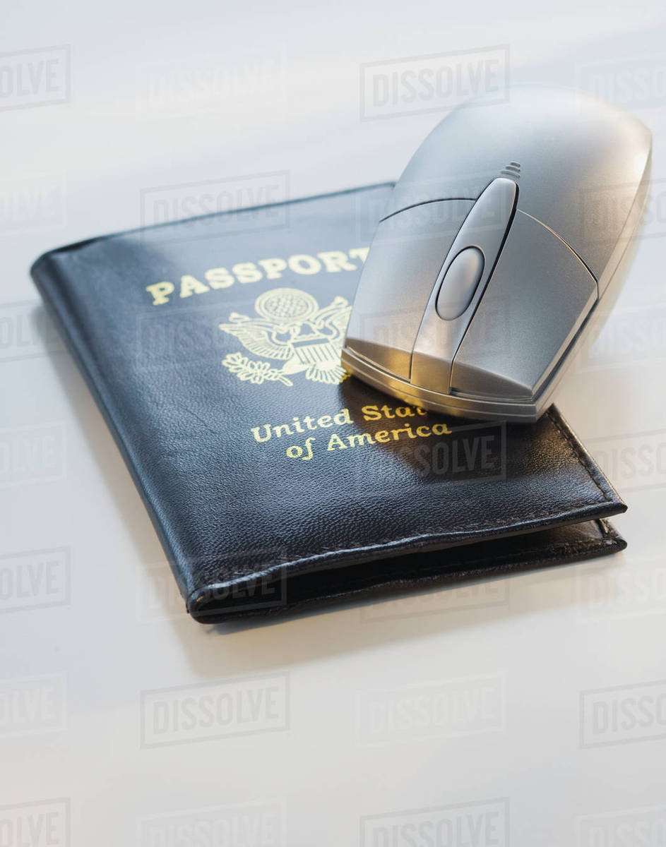 Computer mouse on passport - Stock Photo - Dissolve