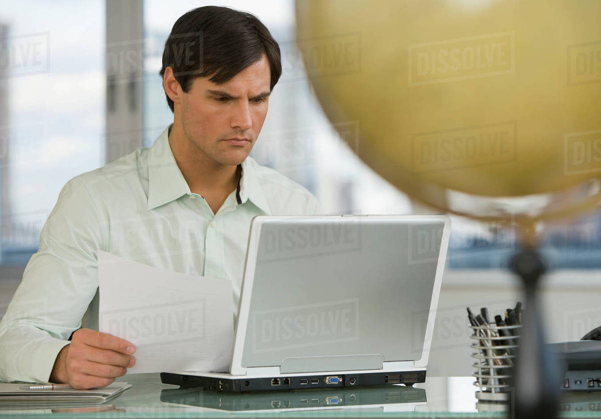Businessman looking at laptop - Royalty-free Stock Photo | Dissolve