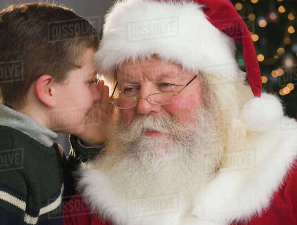 Boy whispering in Santa Claus’s ear - Royalty-free Stock Photo | Dissolve