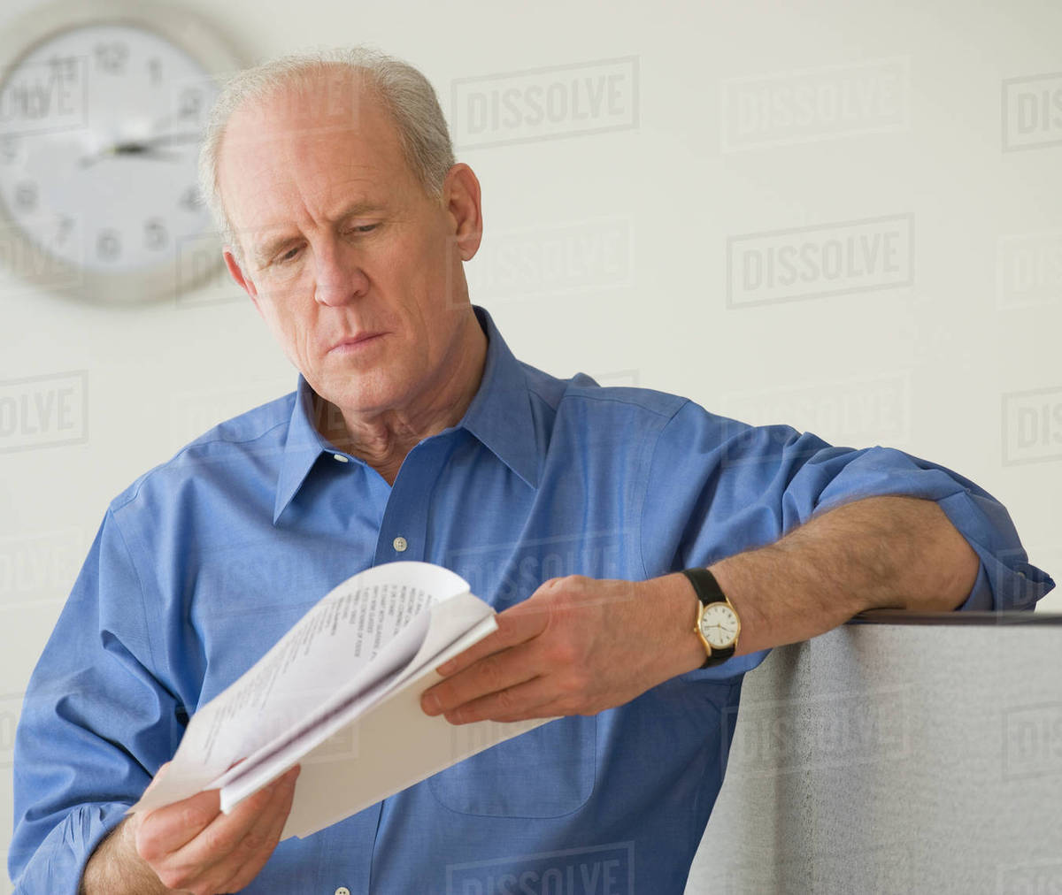 Senior businessman reading paperwork - Stock Photo - Dissolve