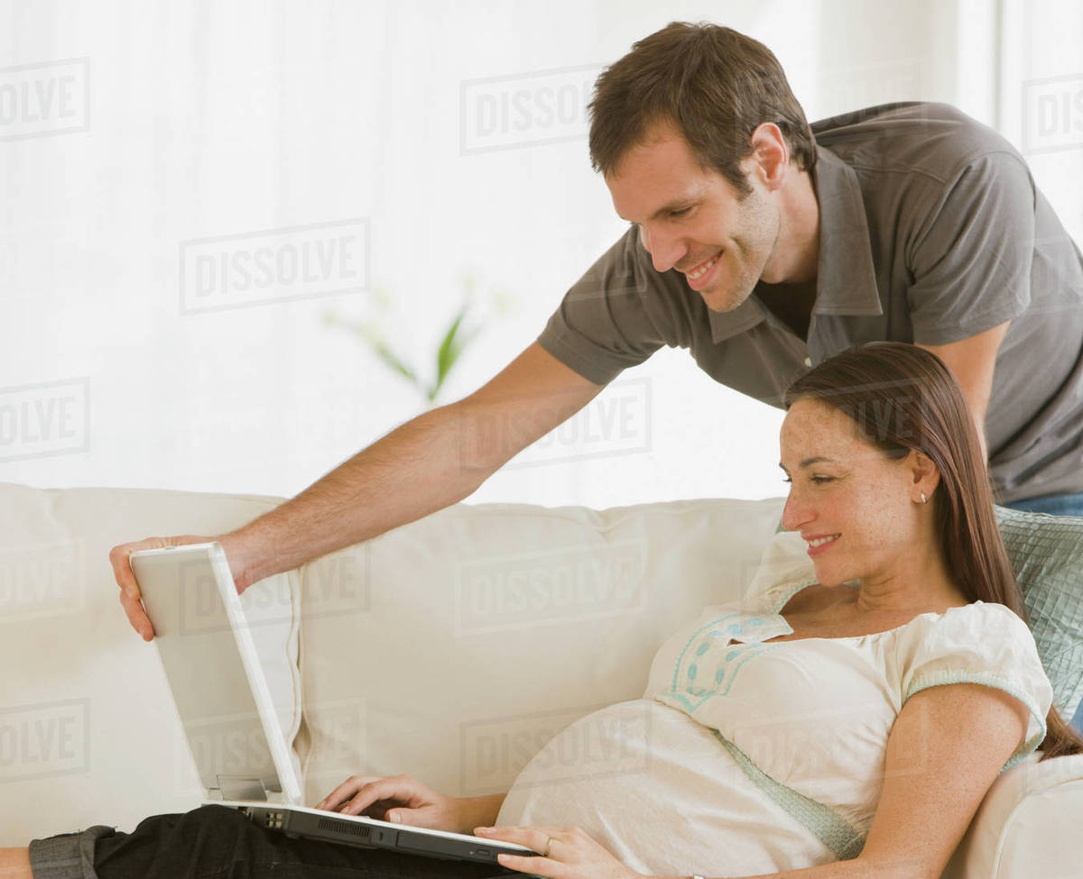 Pregnant Hispanic couple looking at laptop - Royalty-free Stock Photo ...