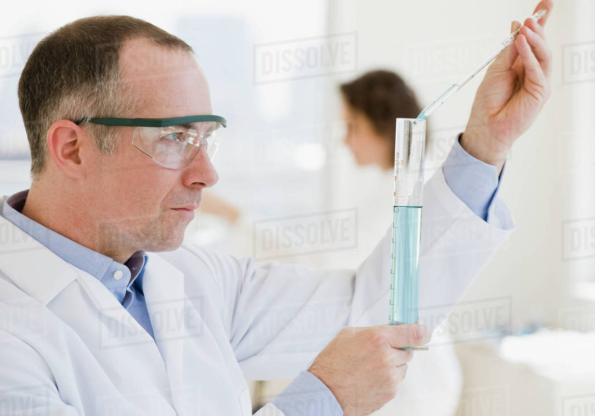 Male scientist measuring liquid in vial - Royalty-free Stock Photo ...