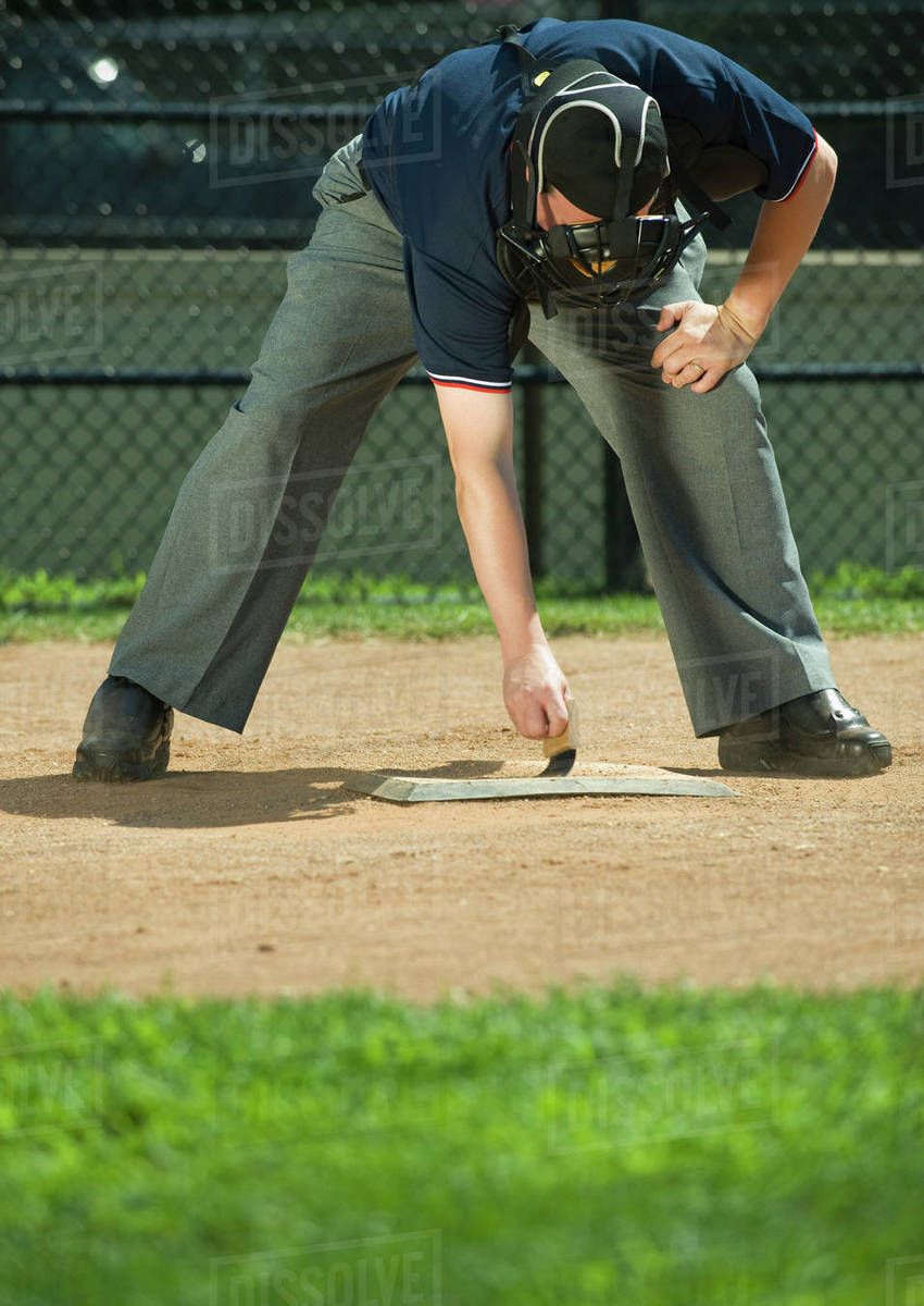 Baseball umpire sweeping home plate - Royalty-free Stock Photo | Dissolve