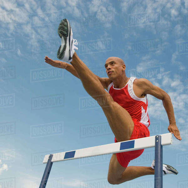 Runner jumping over hurdle - Royalty-free Stock Photo | Dissolve