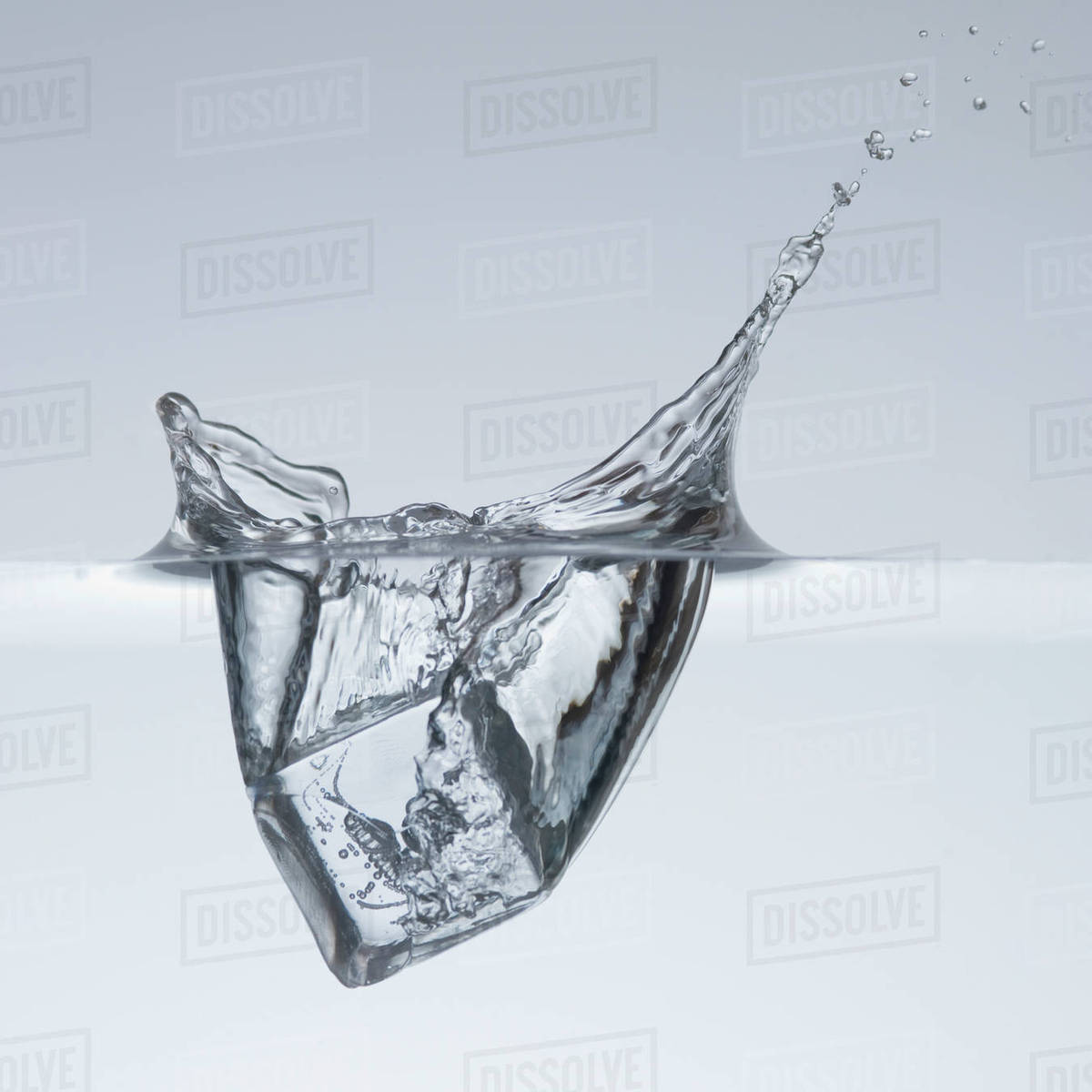 Ice cube splashing in water - Stock Photo - Dissolve