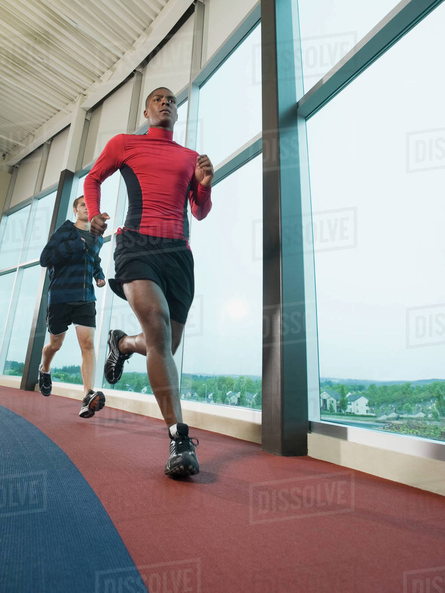 Men running on indoor track - Royalty-free Stock Photo | Dissolve